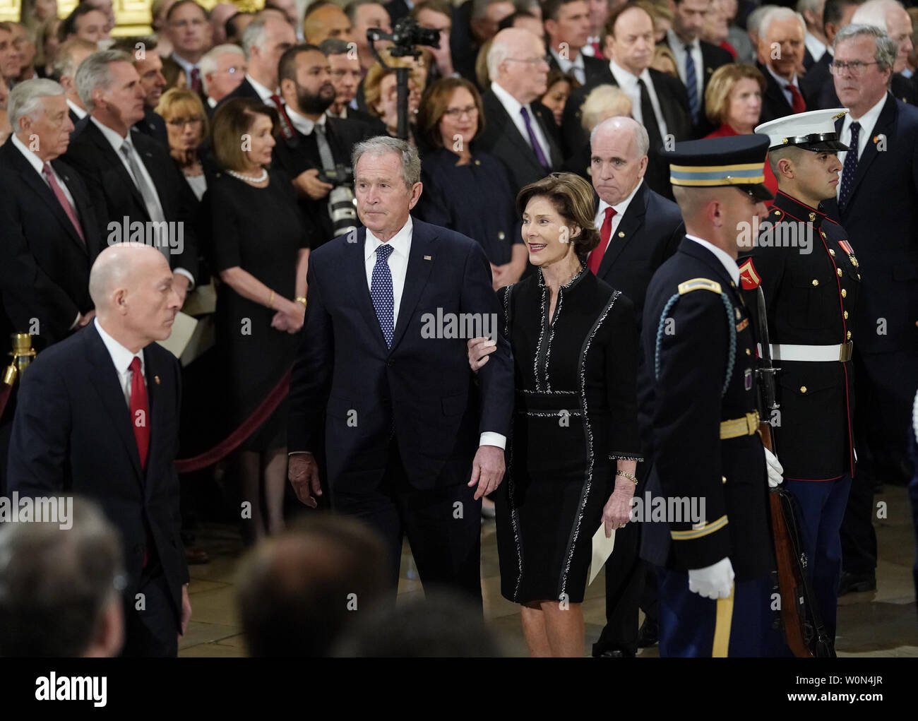 Former President George W. Bush, former first lady Laura Bush walk past ...