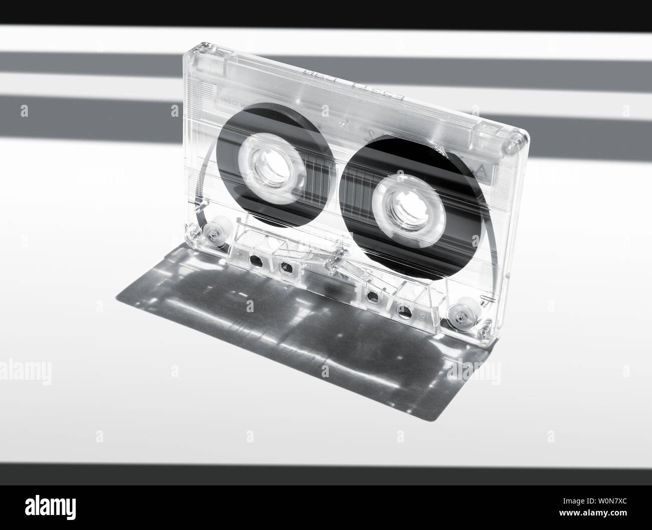 Transparent plastic C90 compact cassette audio tape casting a shadow ...