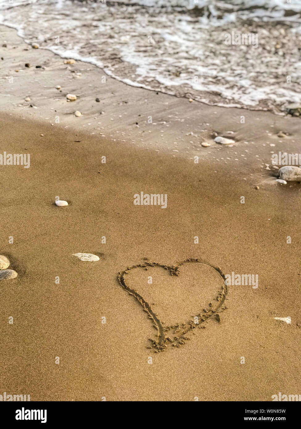 Heart drawn to waves and Sands drawn by the sea shore Stock Photo - Alamy