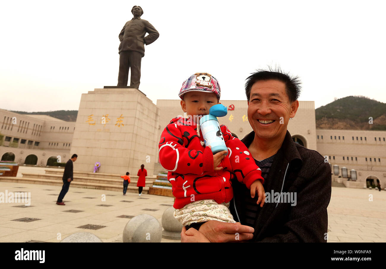 A Chinese father holds his son on the square of the Revolution Museum ...