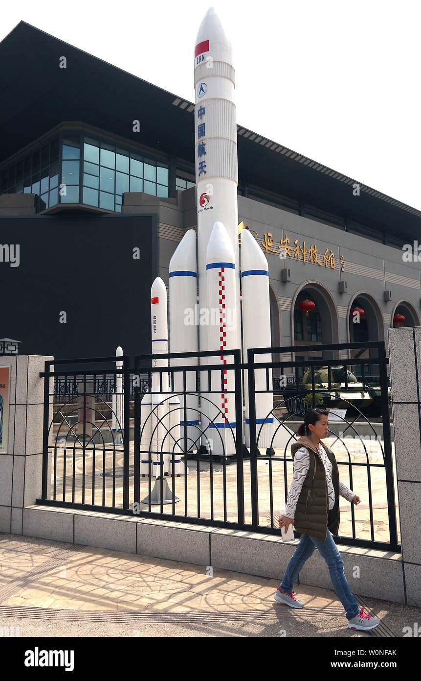 Chinese walk by a model of China's Long March rocket on display outside ...
