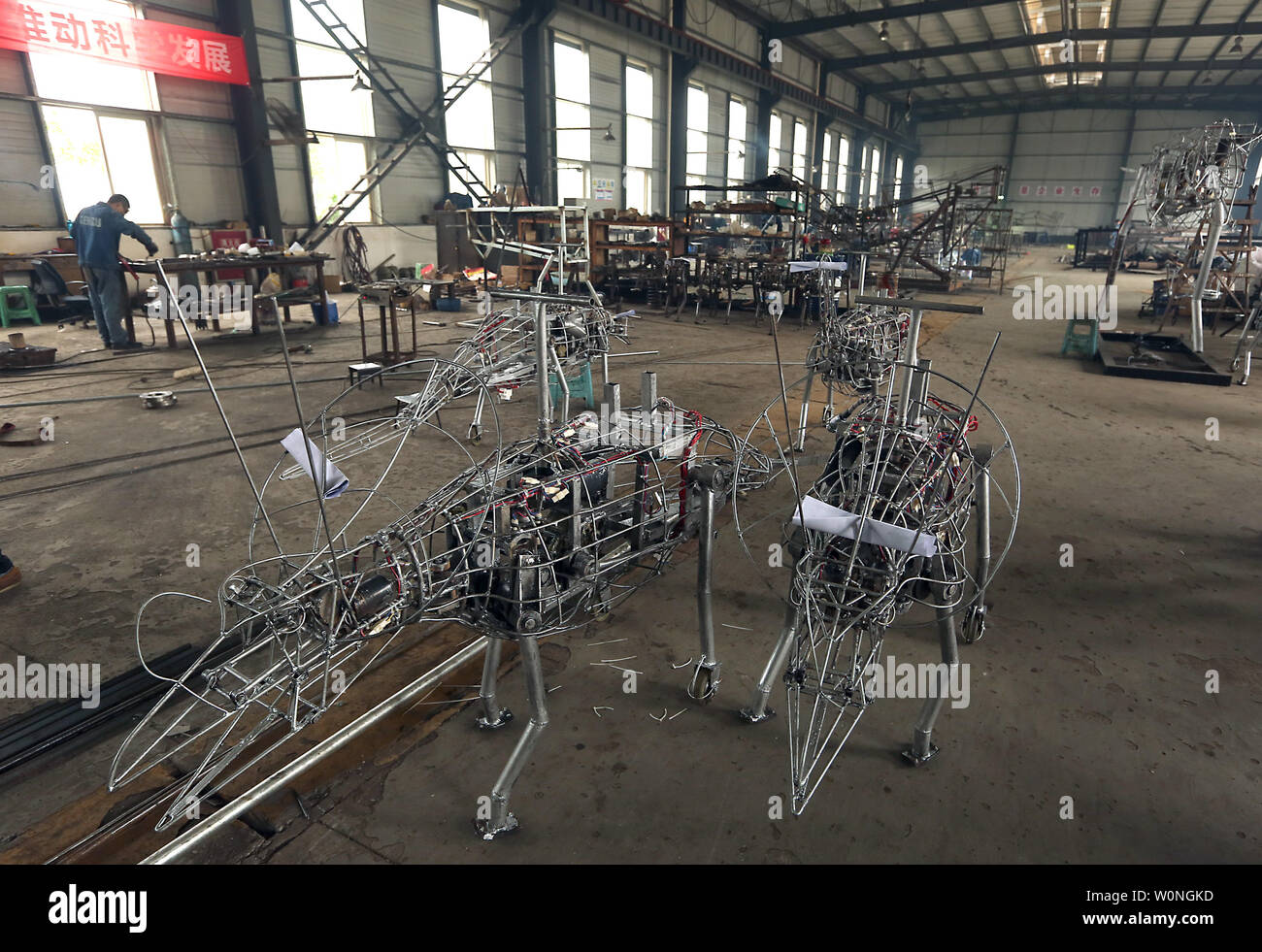 Chinese technicians work on the alloy exoskeletons of robotic dinosaurs ...