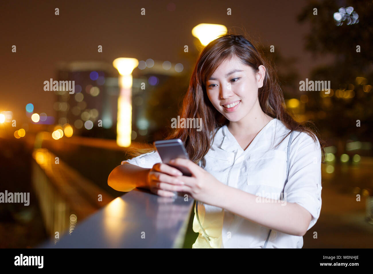 beautiful asian girl using mobile phone at night Stock Photo - Alamy