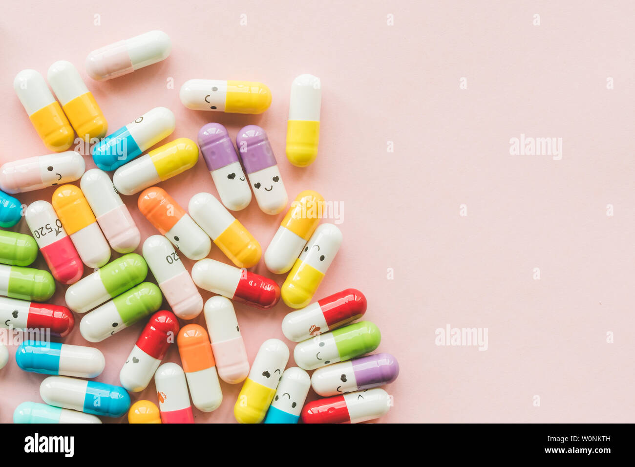 Pile of funny colored capsule on a pastel paper pink background Stock ...