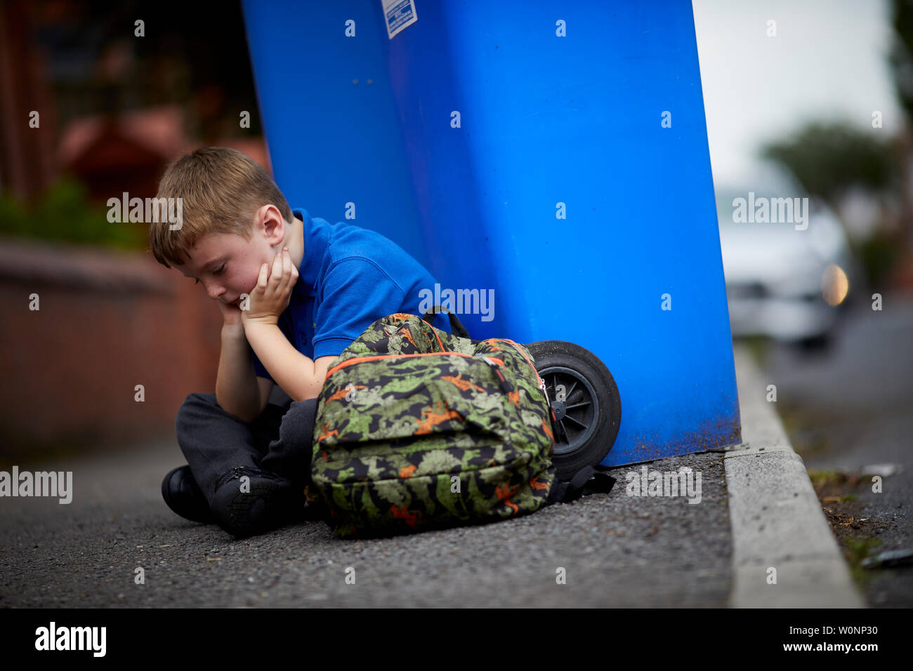 Posed by model, Troubled small child in school uniform running away and ...