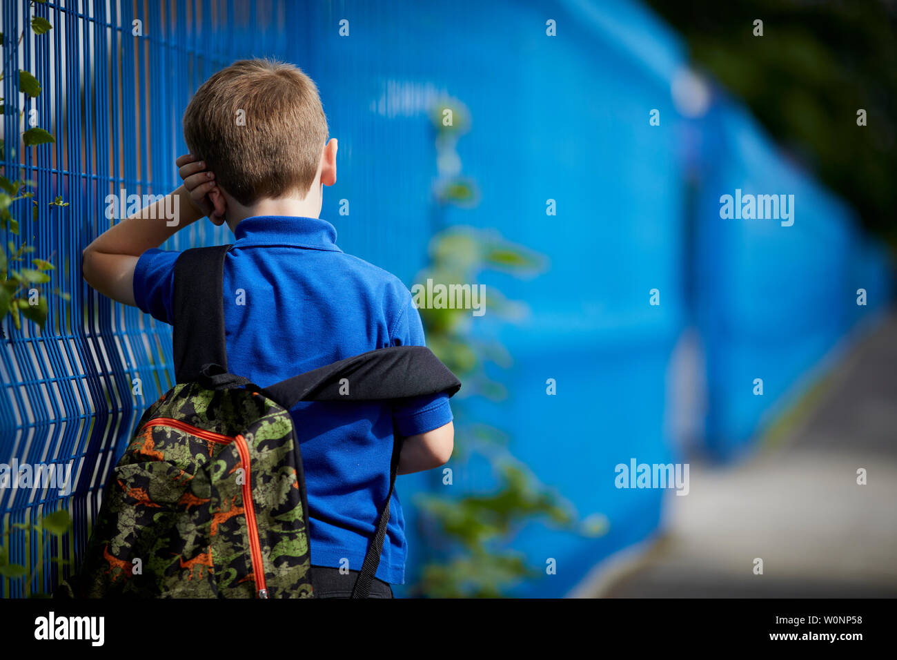Posed by model, Troubled small child in school uniform running away and ...