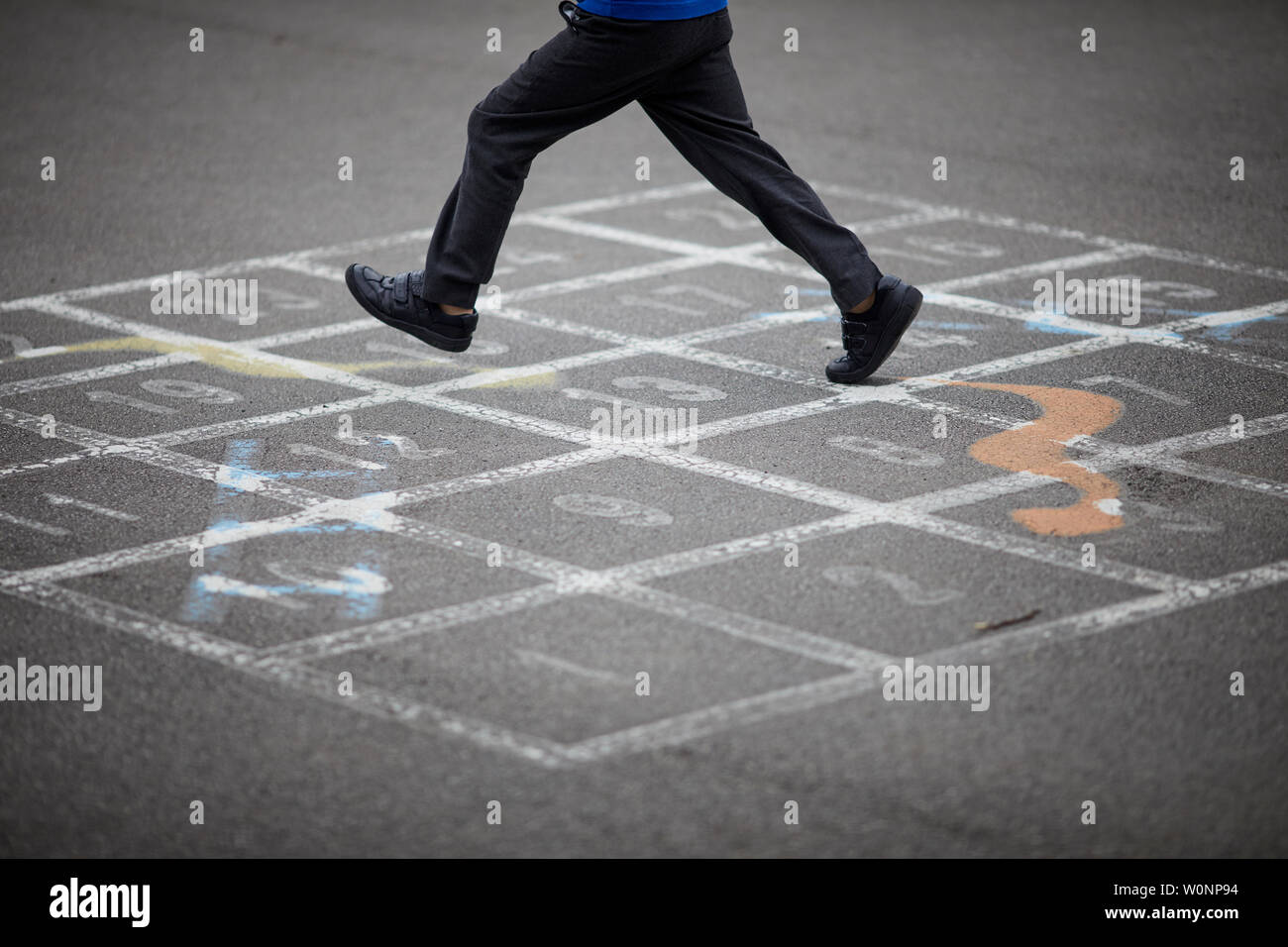 Posed by model, small child in school uniform playing traditional ...