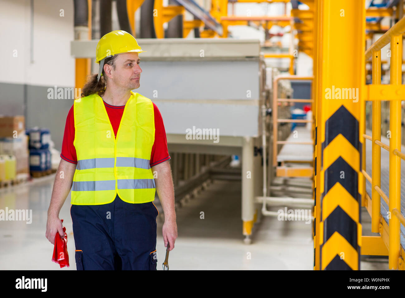 Factory worker in yellow reflective suit Stock Photo - Alamy