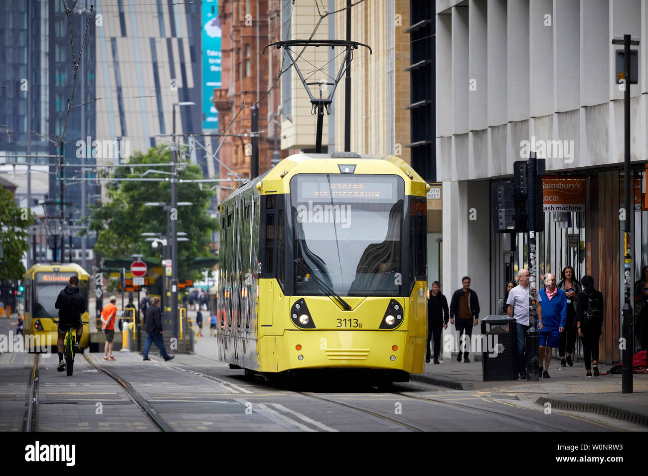 Manchester city centre, Metrolink trams crossing the city along Mosley ...