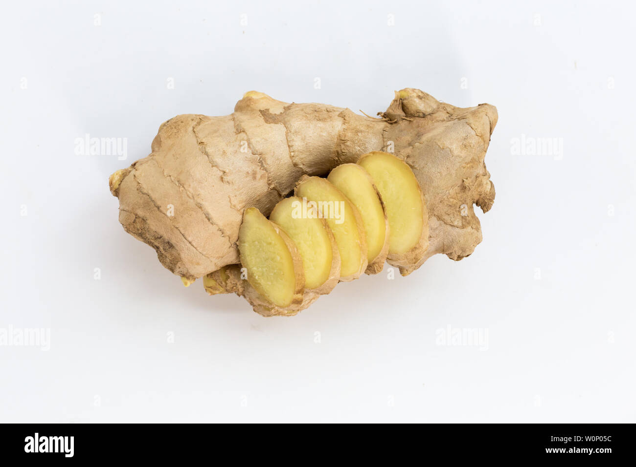 Ginger and cut ginger slices on white background Stock Photo - Alamy