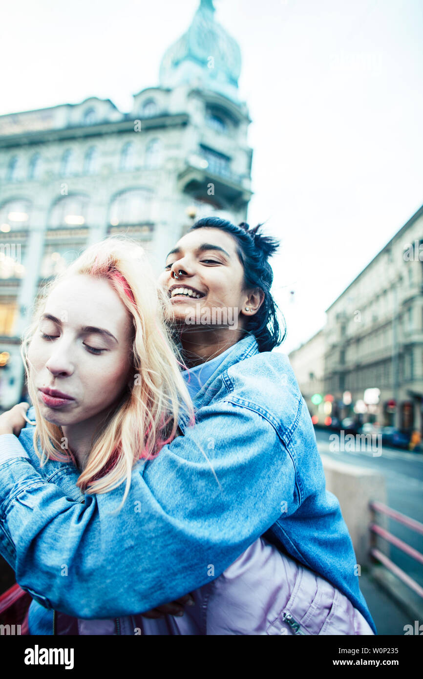 Two teenage girls infront of university building smiling, having fun ...