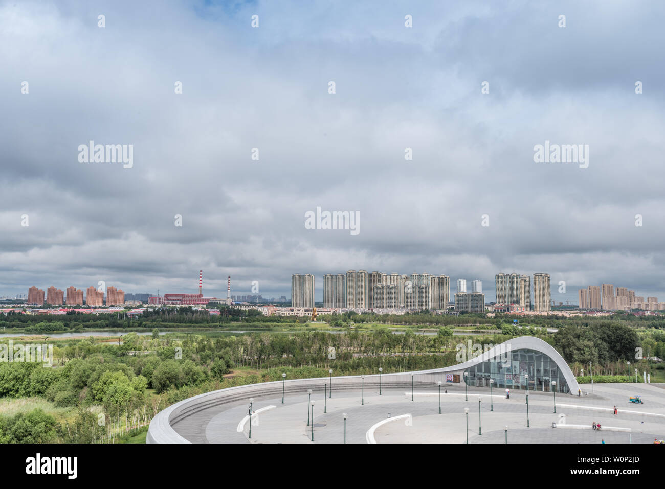 Cloudy weather overlooks riverside green space building Stock Photo - Alamy