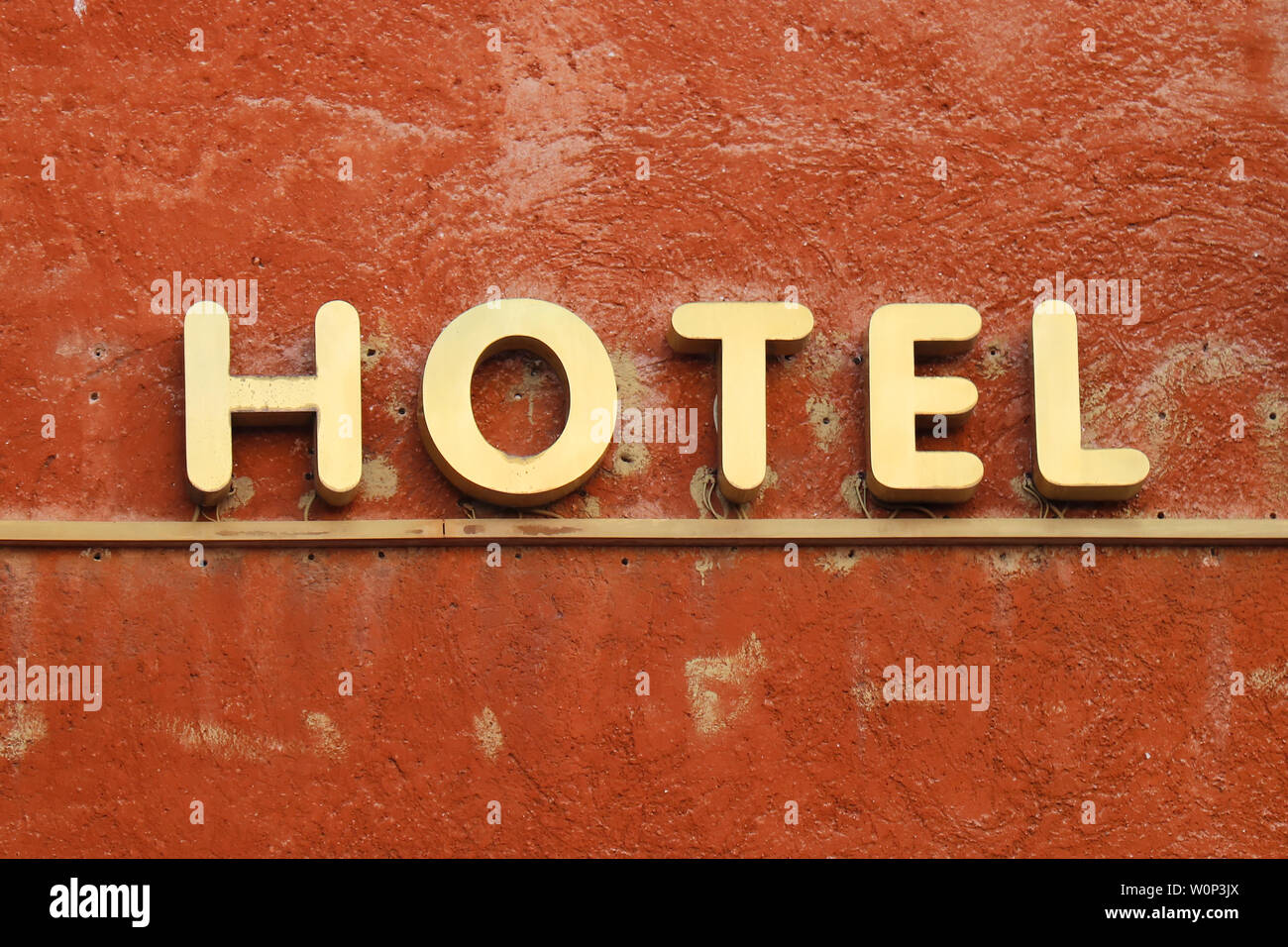 Gold hotel sign outside on building orange facade Stock Photo - Alamy