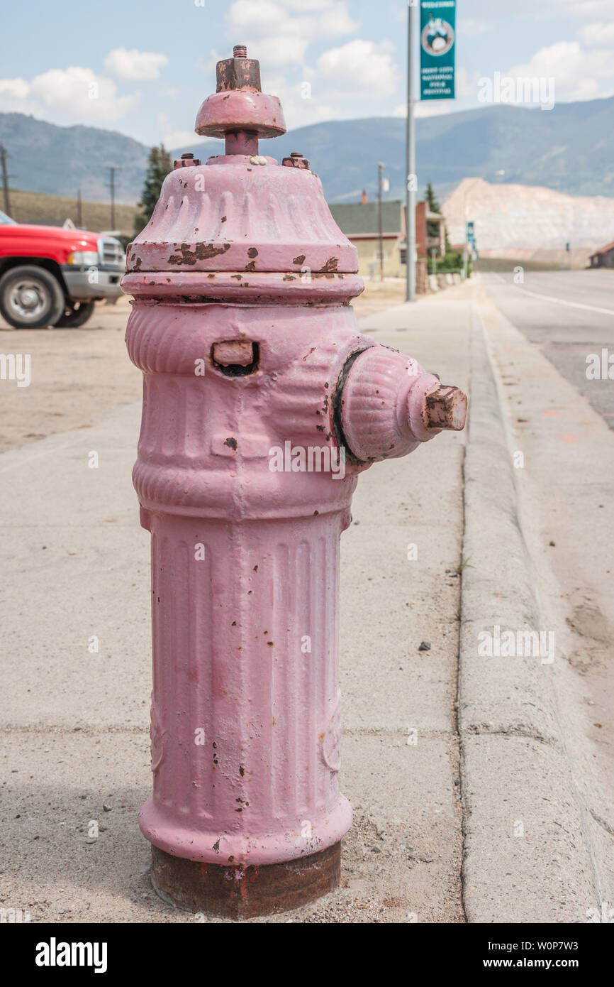 Pink Fire Hydrant collecting rust on a city sidewalk Stock Photo - Alamy