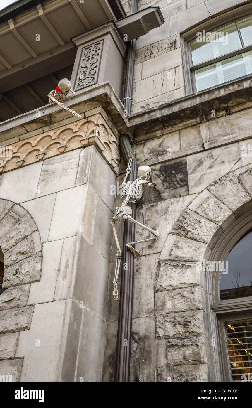 One skeleton leaning over and reaching out to help a second skeleton ...