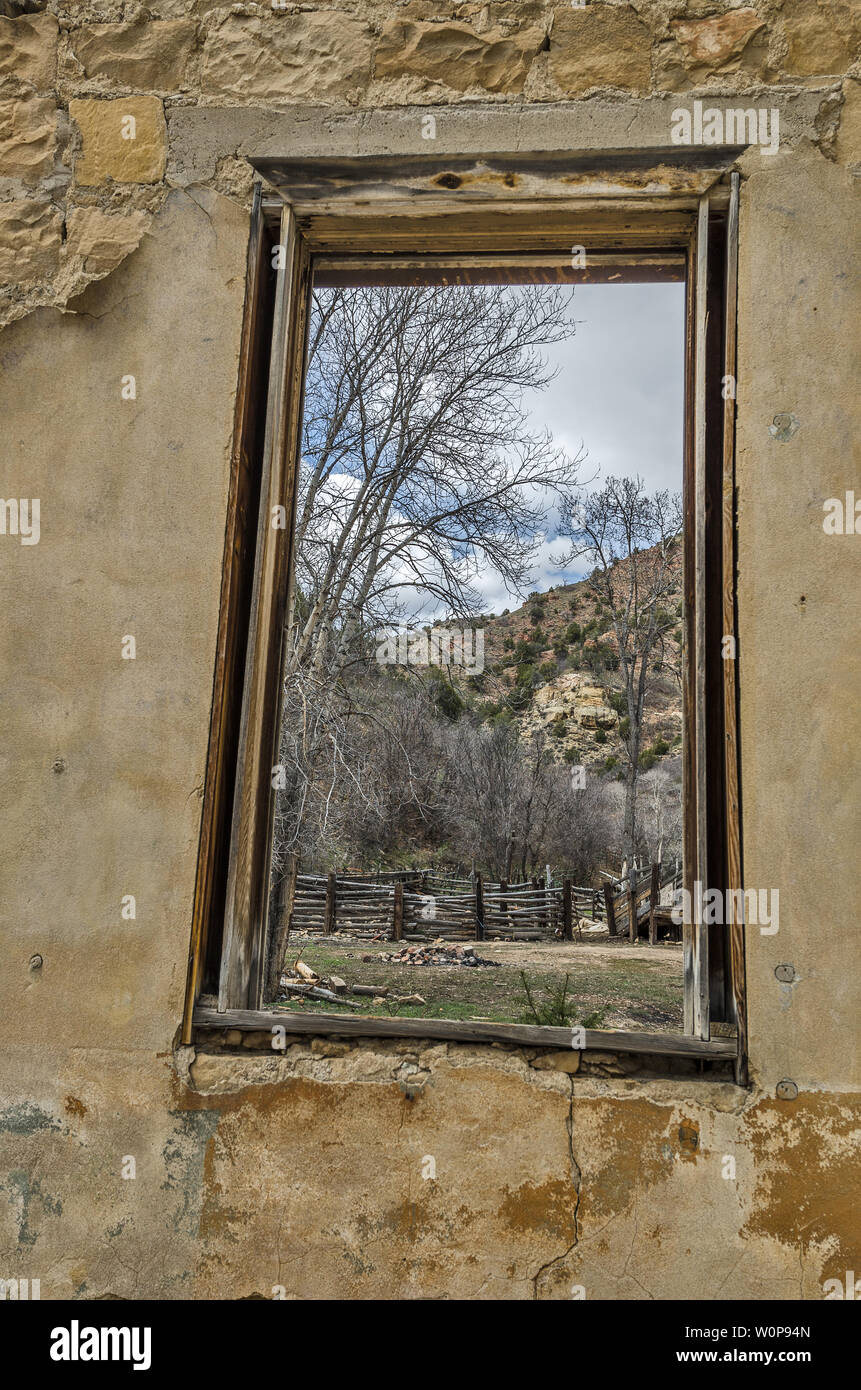 Looking at a stock pen from a wood framed window in a dilapidated ...
