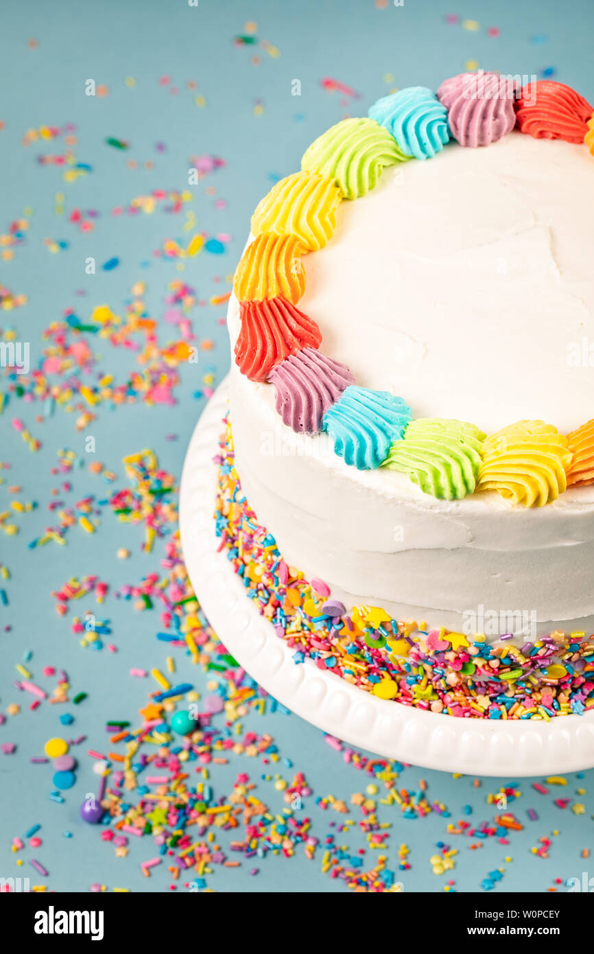 overhead view of a Birthday cake with rainbow icing and colorful ...