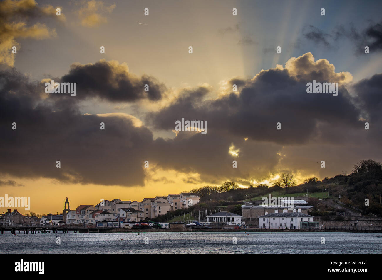Dramatic clouds and sun rising over Swanage Bay Stock Photo - Alamy