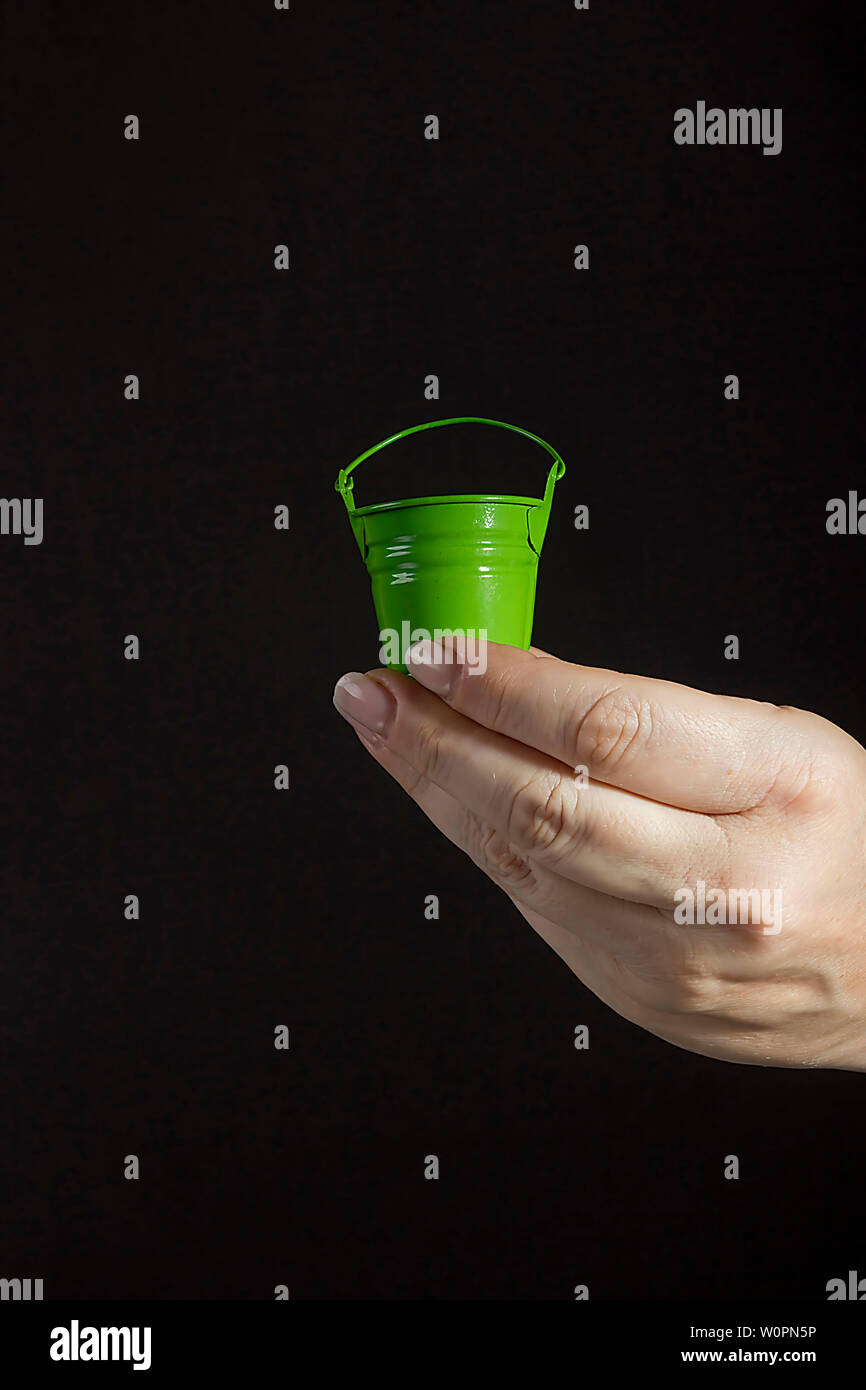 Female hand with a small green bucket Stock Photo - Alamy