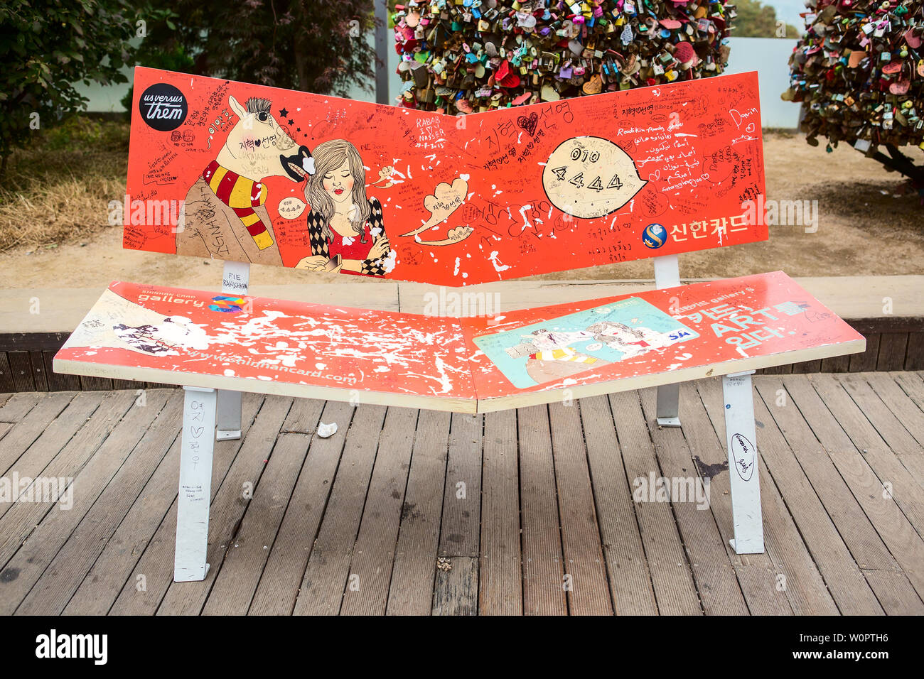 Wooden red bench with bright pictures in the park. Close-up. Seoul ...