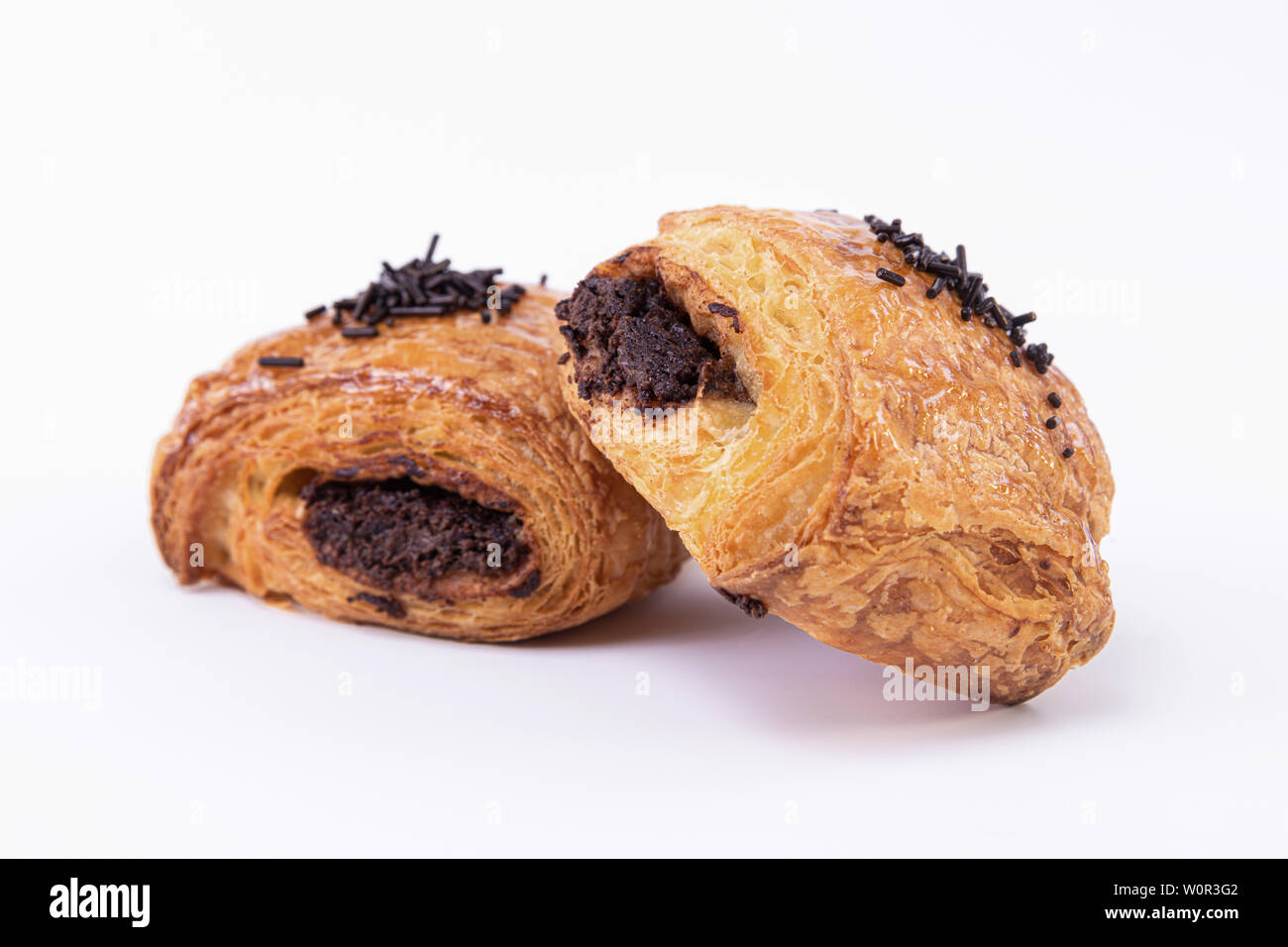 Detail view of a pair of puff pastry rolls filled with chocolate on a ...