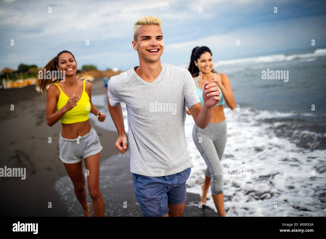 Group of friends running at the beach hi-res stock photography and ...