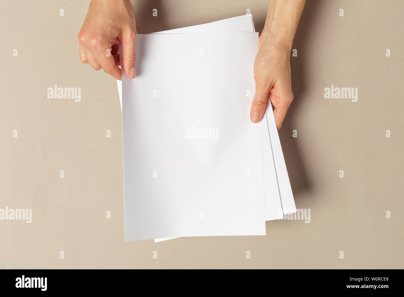 Hand holding papers a4 size Stock Photo - Alamy