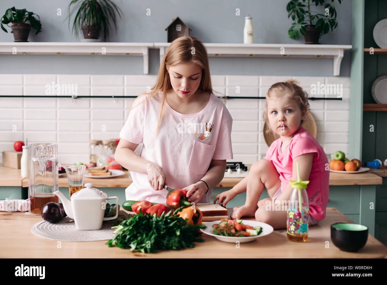 Mother cooking dinner on kitchen with her little cute kid Stock Photo ...