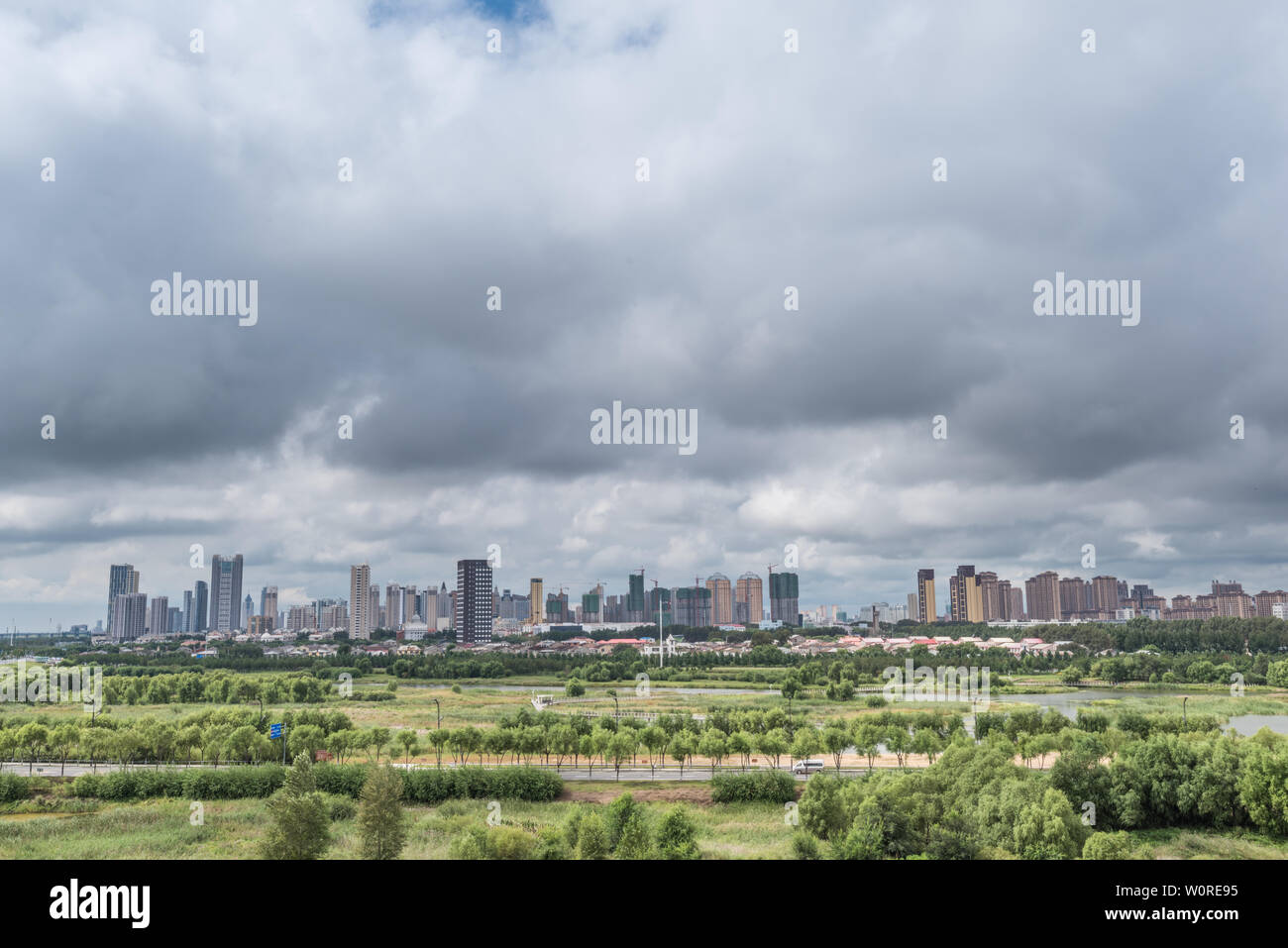 Cloudy weather overlooks riverside green space building Stock Photo - Alamy
