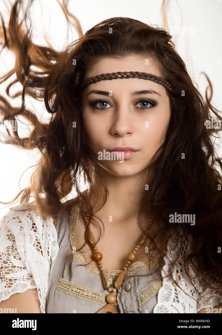 Young beautiful hippie boho woman with fluttering hair having fun poses ...