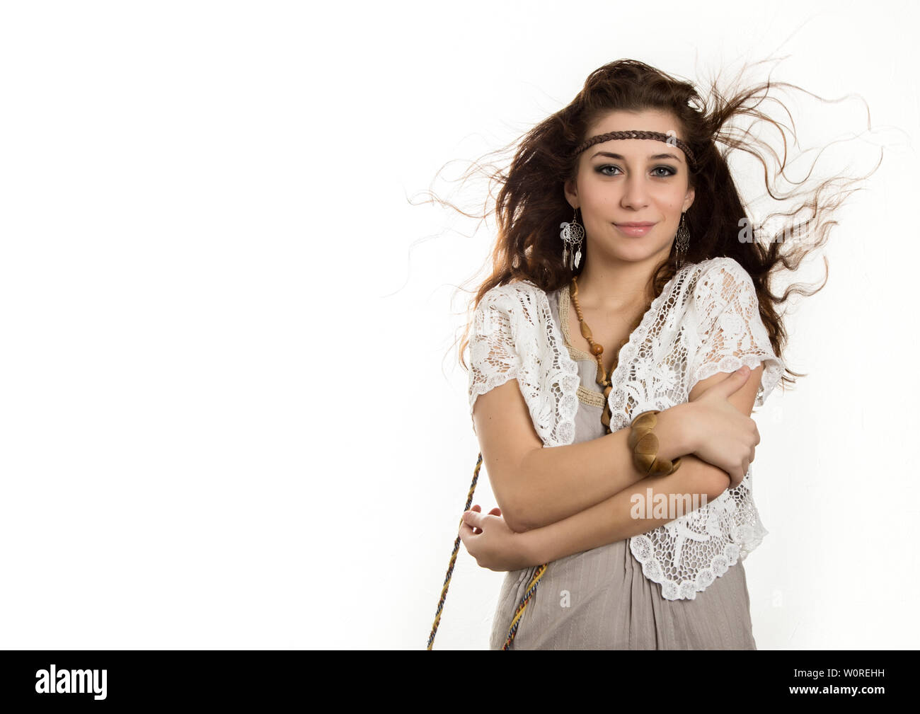 Young beautiful hippie boho woman with fluttering hair having fun poses ...