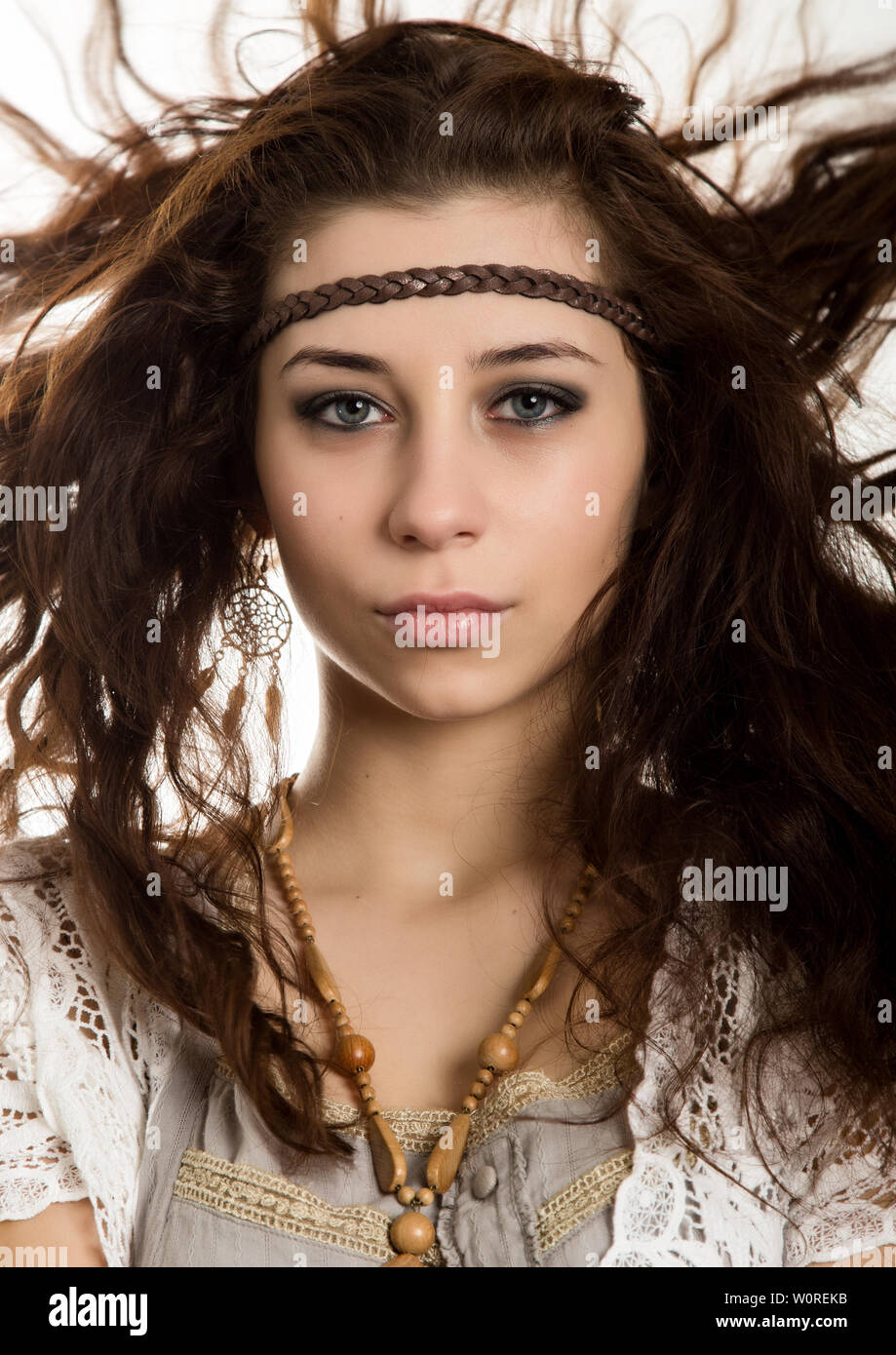 Young beautiful hippie boho woman with fluttering hair having fun poses ...