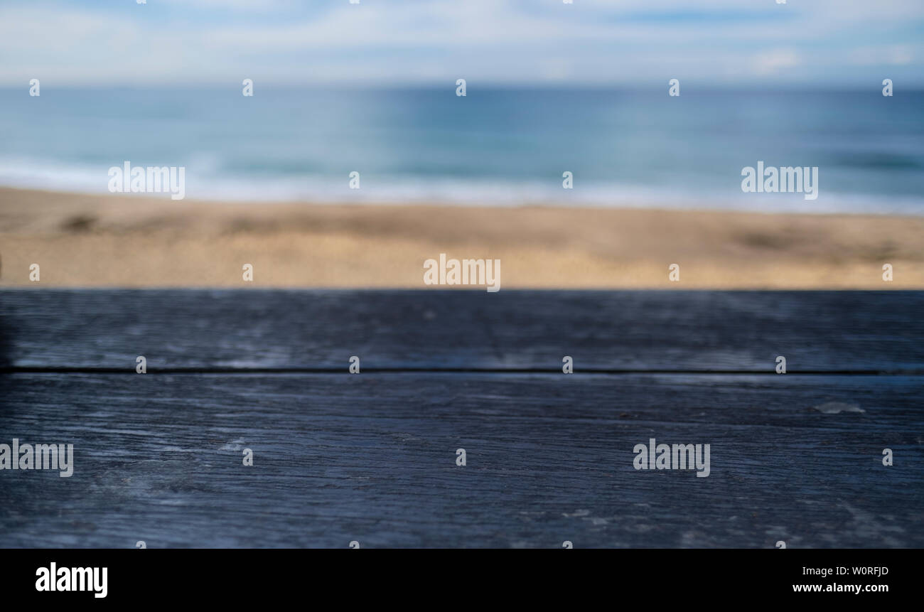 Close up of a timber bench surface overlooking an empty beach Stock ...
