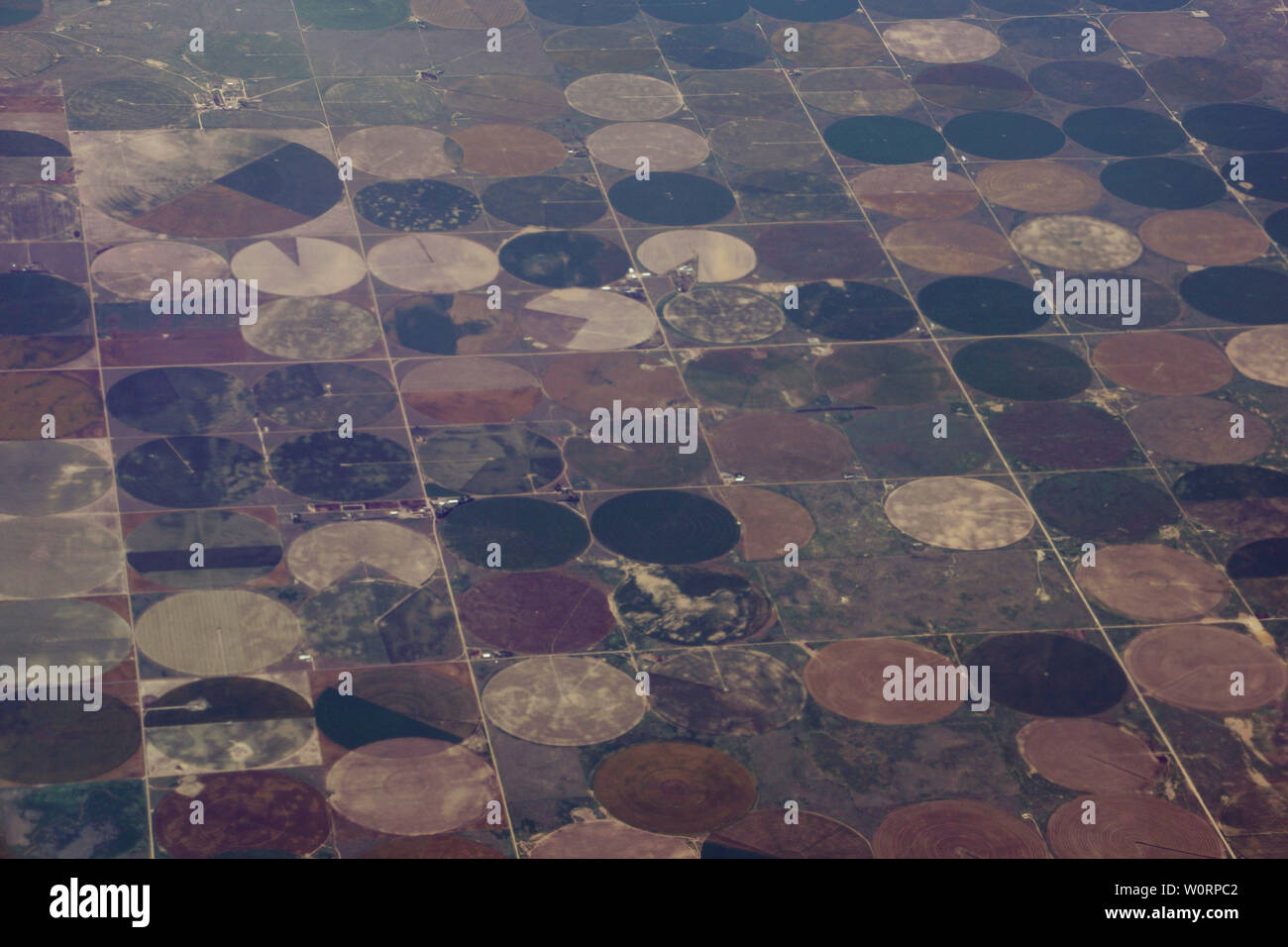 High aerial view of the crop circles created in farm fields by center ...