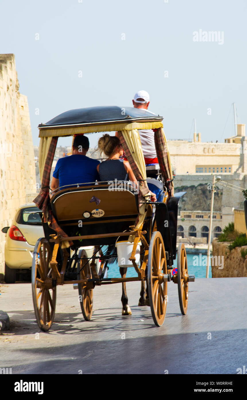 Karozzin horse drawn carriage carries tourist couple in Valletta ...