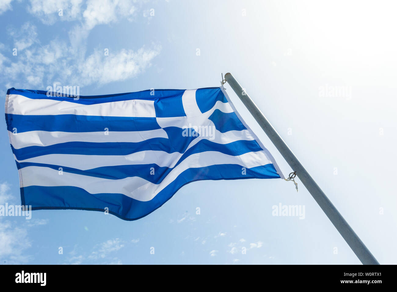 Flag of Greece Flying in Wind and Blue Sky Stock Photo - Alamy