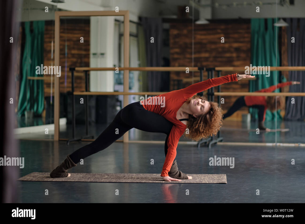 Young woman doing revolved side angle pose, parivrtta parsvakonasana ...