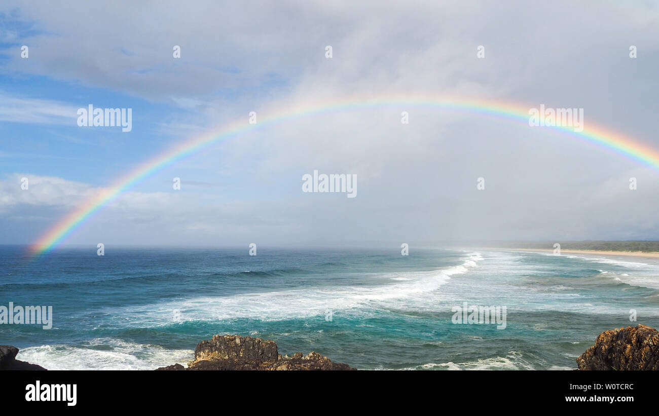 Curves and lines. Rainbow arch across the beach and Pacific Ocean ...
