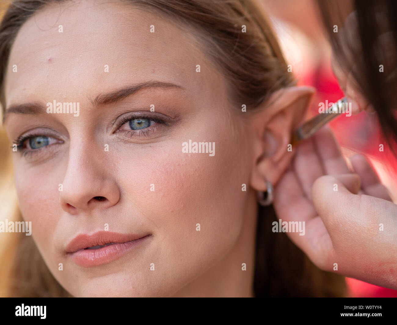Makeup on the ears to a model to turn her into an elf Stock Photo - Alamy