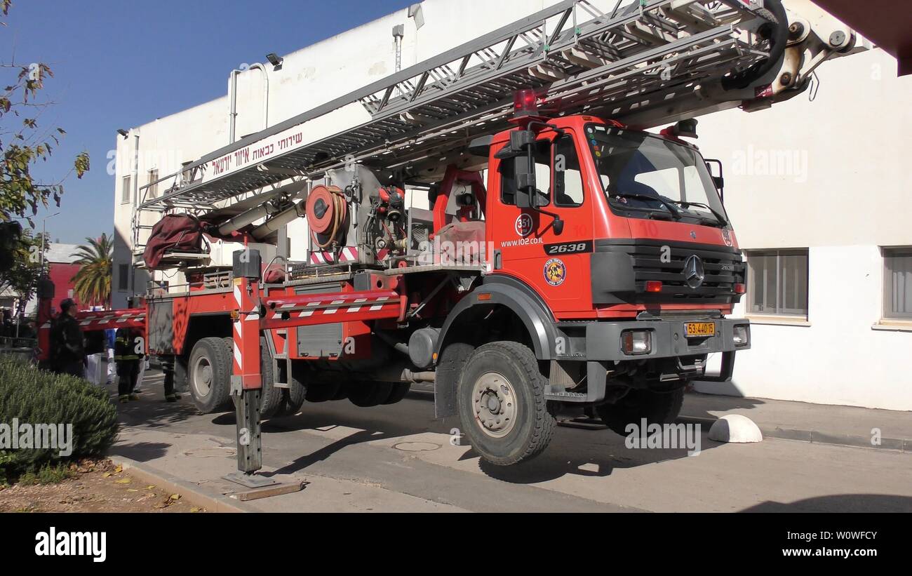 Firefighter driver stabilizes a Fire Engine Crane Truck by raising all ...