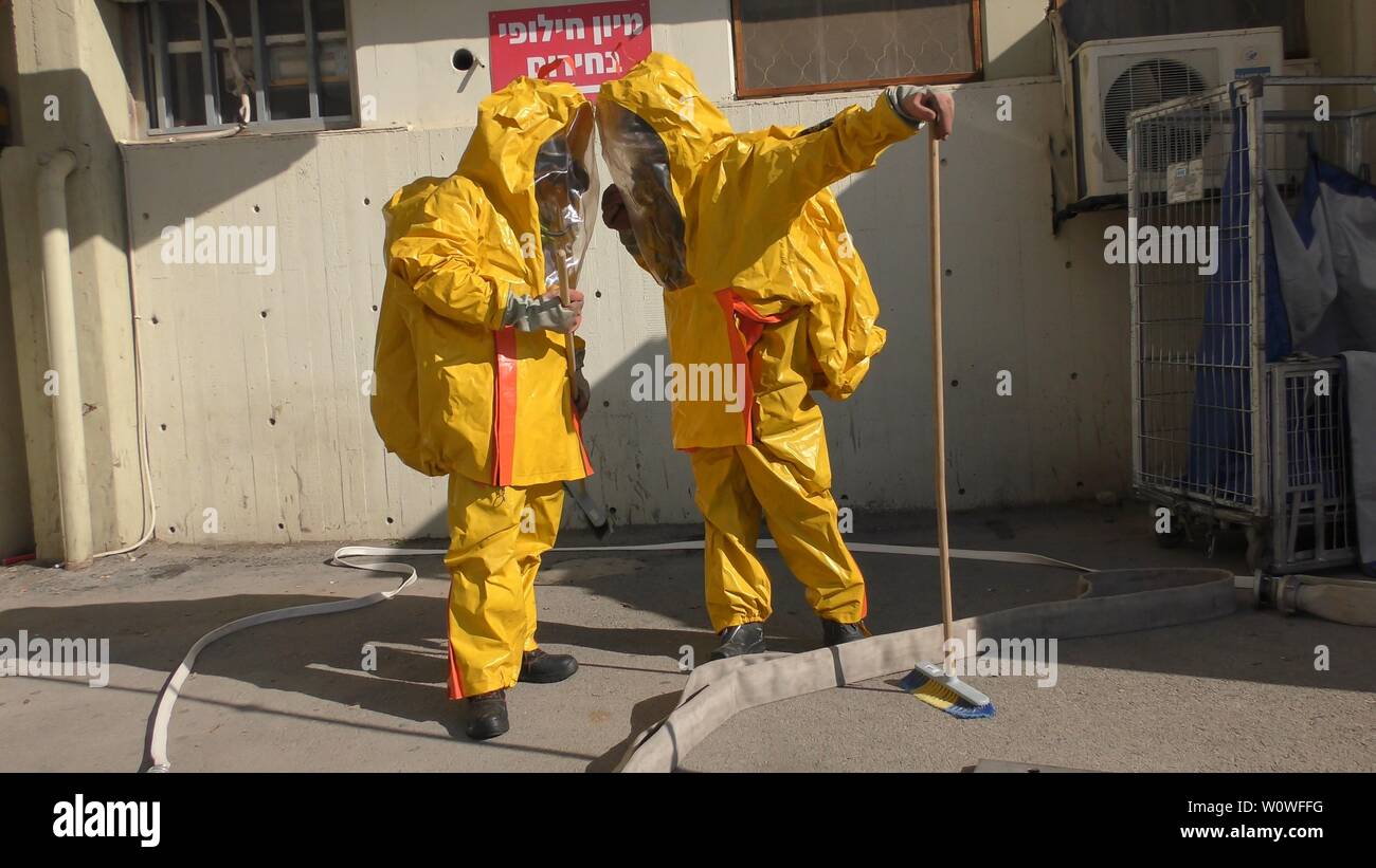Two firefighters dressing protective suites ready to clean victims from ...