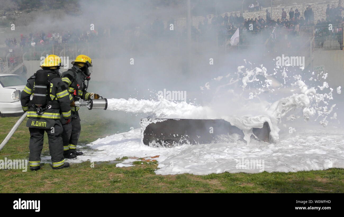 Firefighter from Northern Israel Fire Brigade dispense snow white foam ...