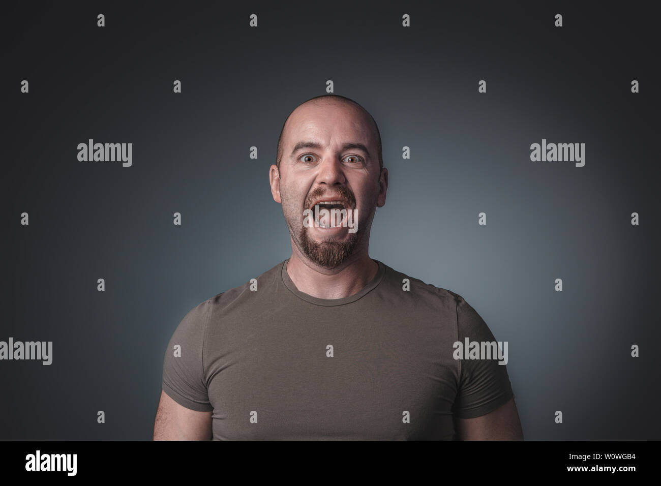 portrait of caucasian man screaming and looking straight in front of ...