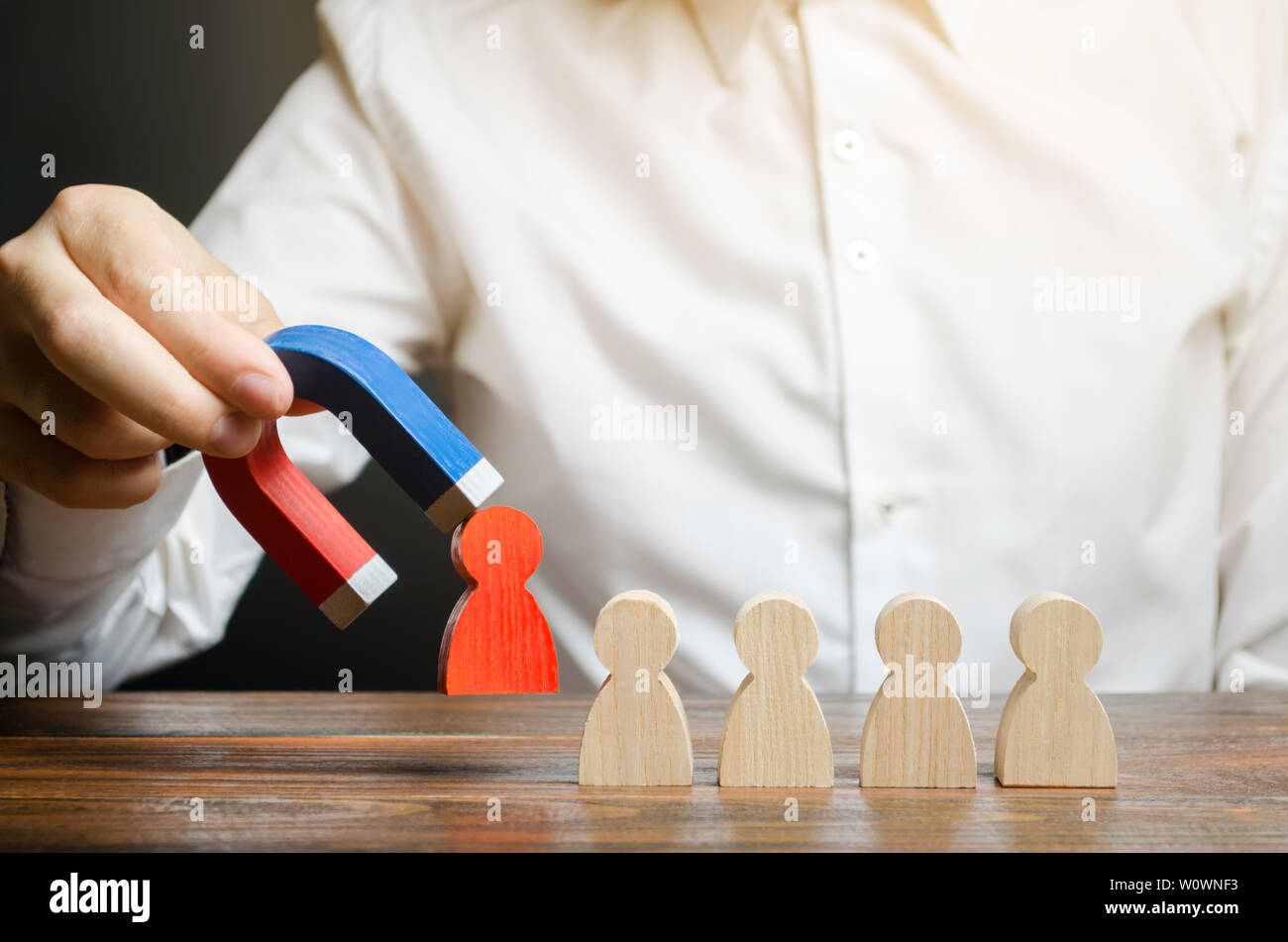The businessman draws a red figure from the team with a magnet. The ...