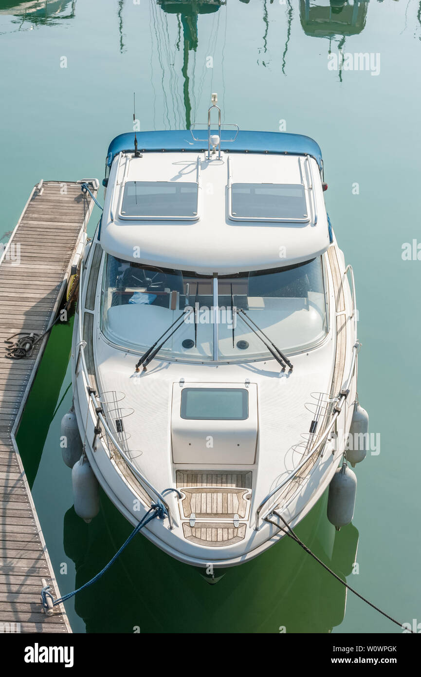 small boat moored to a jetty in a calm water ocean marina Stock Photo ...