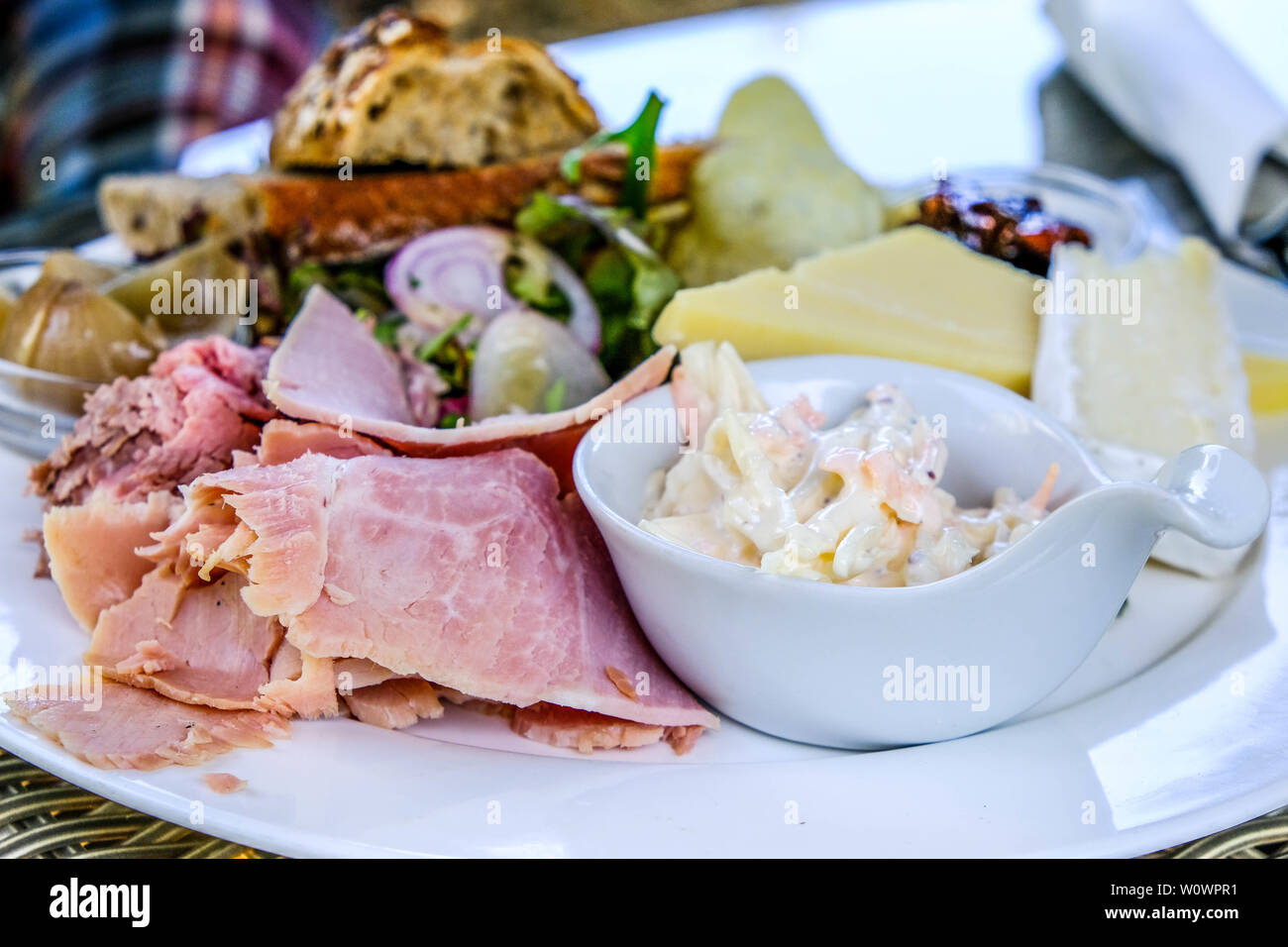 Ploughmans Lunch on a White Plate with Ham, cheese, coleslaw, pickles ...