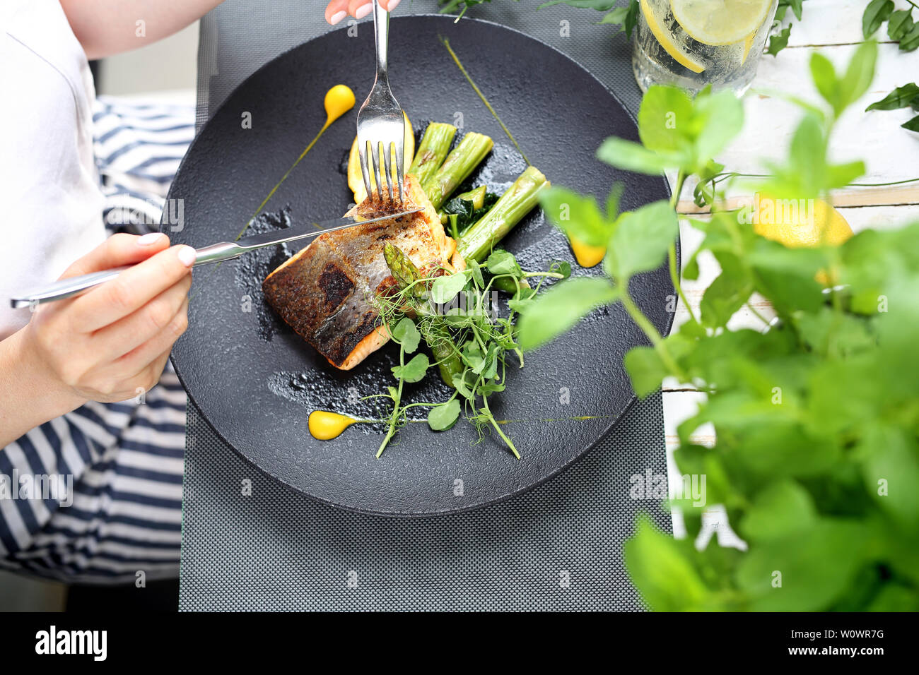 A woman is eating a dish at a restaurant Stock Photo - Alamy