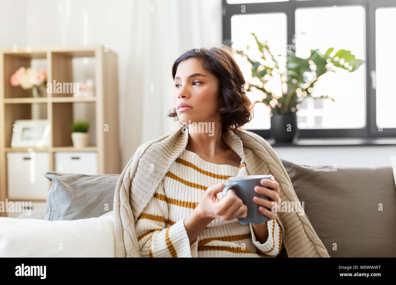 sad sick young woman drinking hot tea at home Stock Photo - Alamy