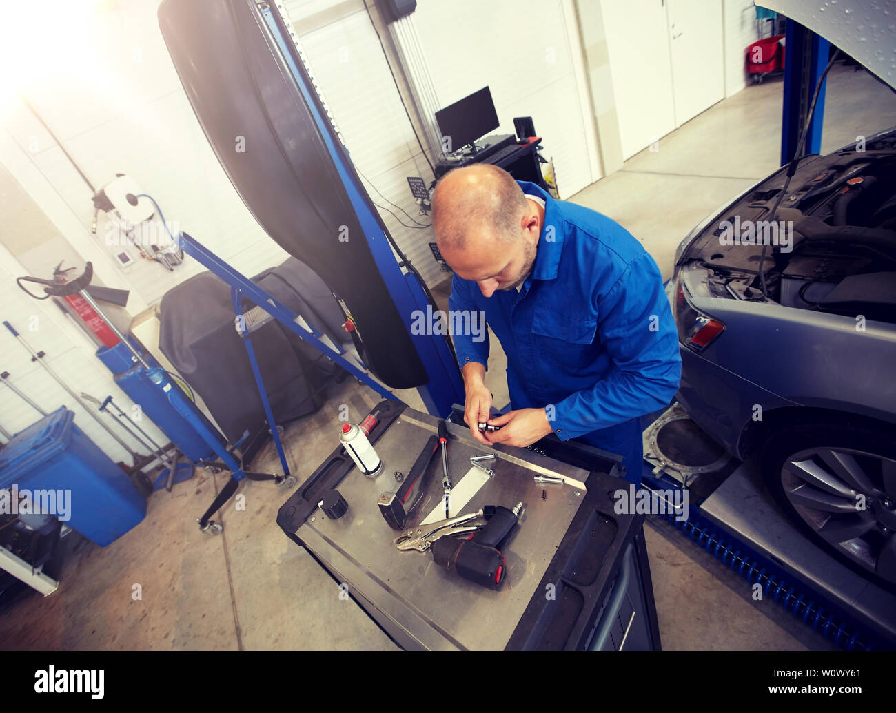 mechanic man with wrench repairing car at workshop Stock Photo - Alamy