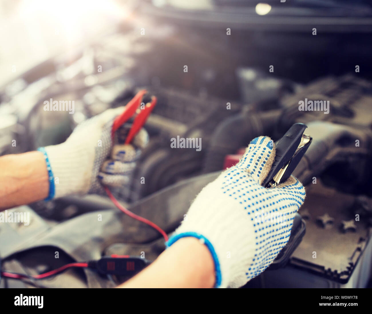 auto mechanic man with cleats charging battery Stock Photo - Alamy